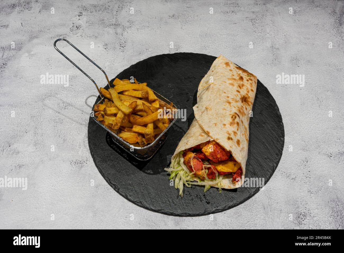 Indian dishe culinary Still Life. Tandoori Wrap served with fries on a ...