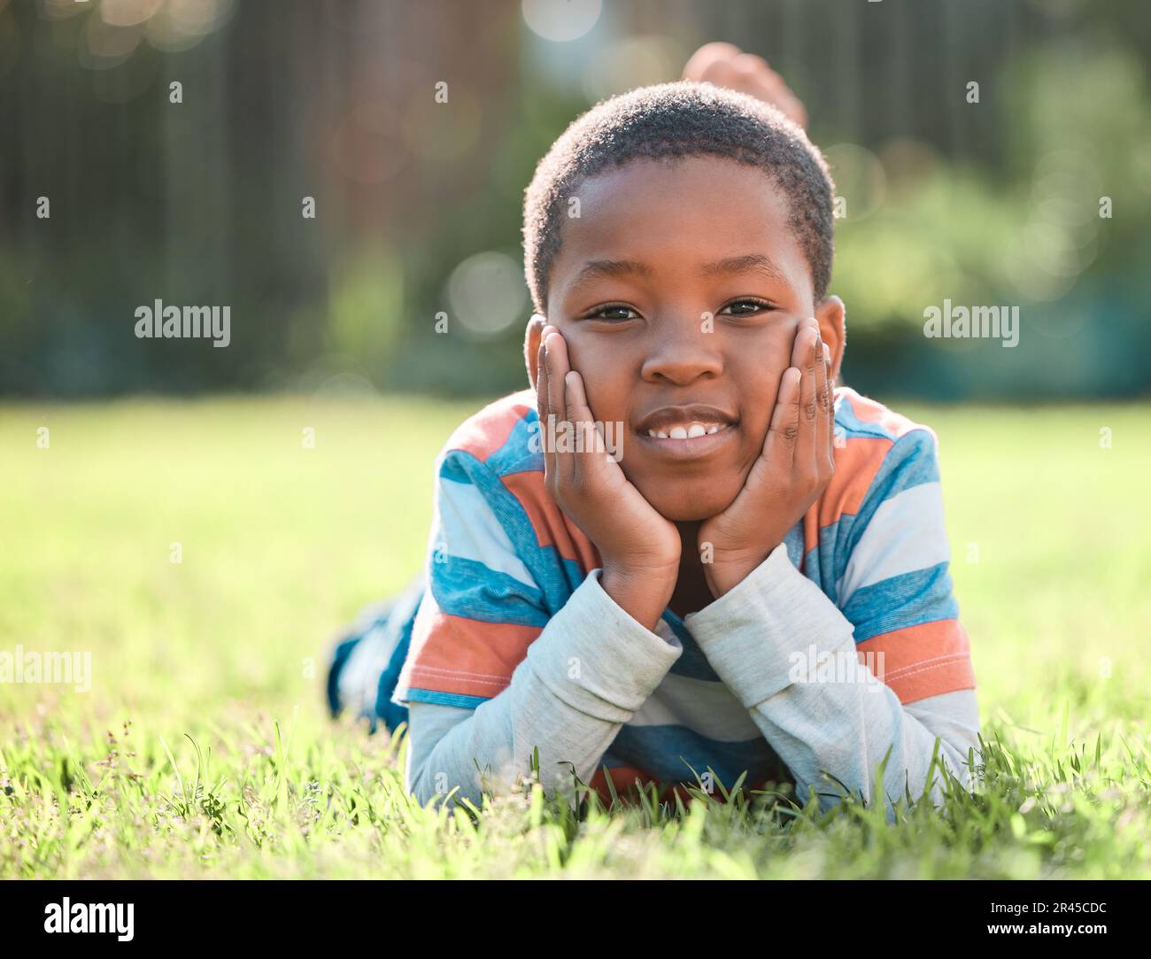 Nature park, portrait of black boy and lying on grass outside. Summer ...