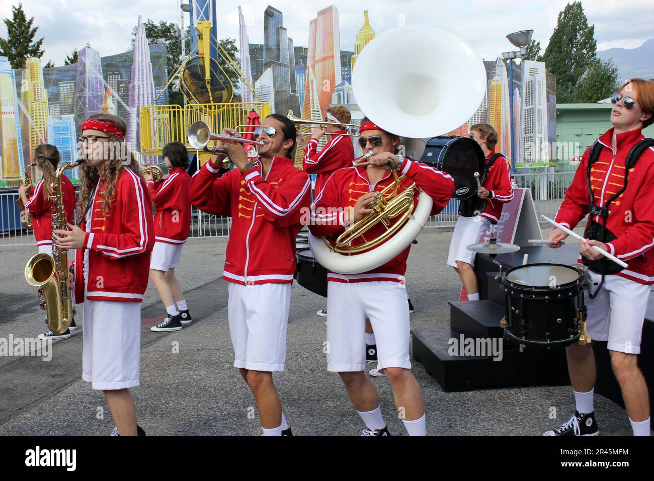 A group of young musicians in red and white uniforms playing their ...