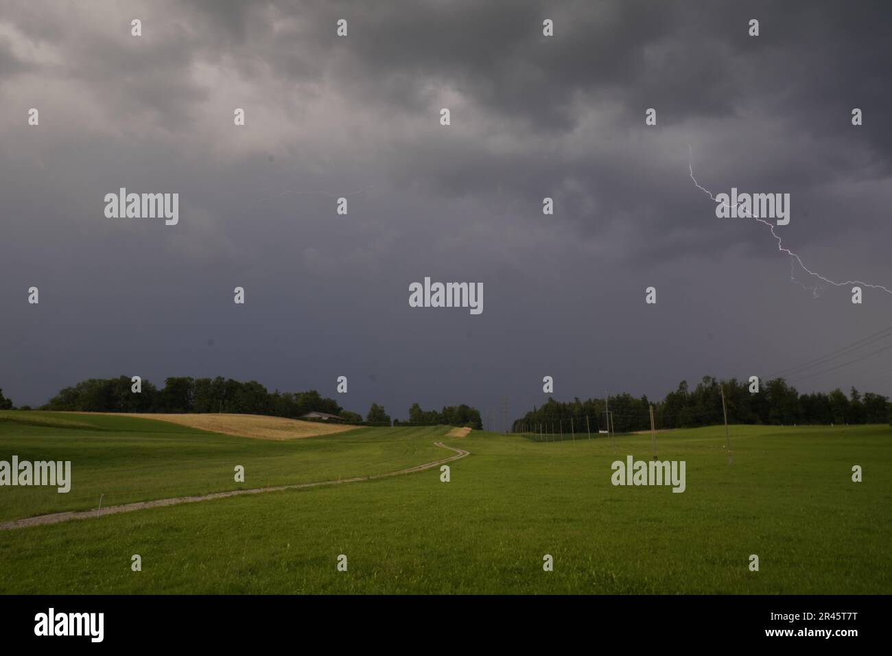 A dramatic landscape featuring a powerful storm rolling in over a lush ...