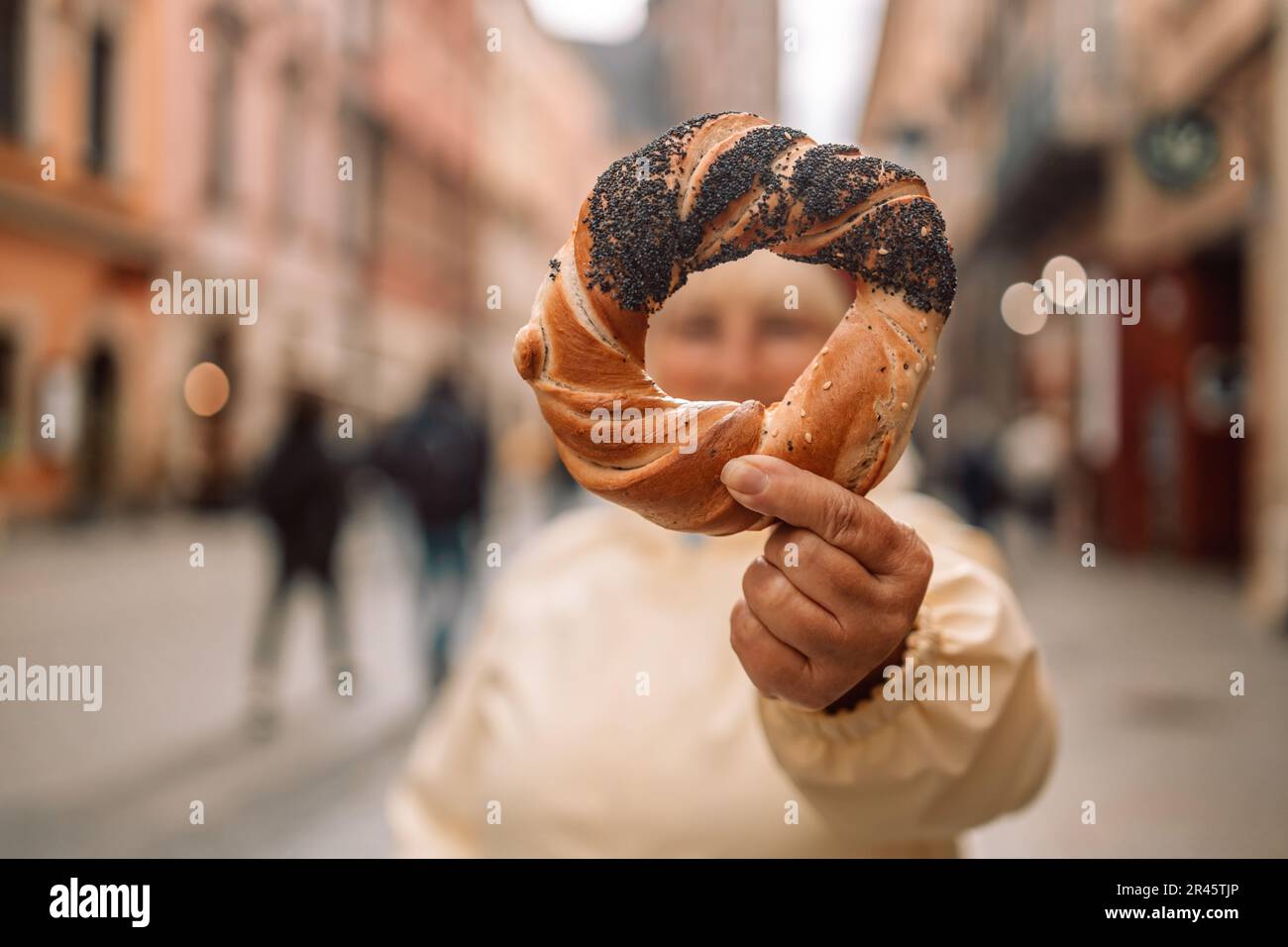 Senior woman holding prezel, traditional polish snack on the Market ...