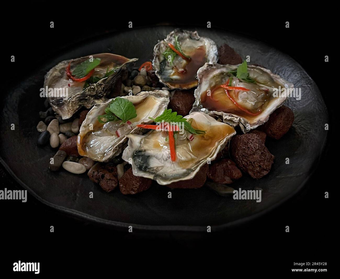 An assortment of fresh seafood, including clams, displayed on a bed of ...