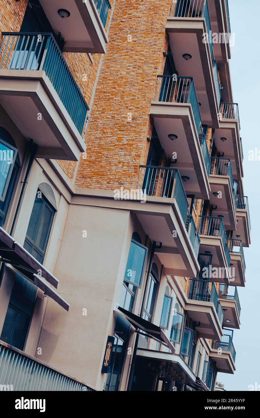 A high-rise apartment building with balconies situated Stock Photo - Alamy
