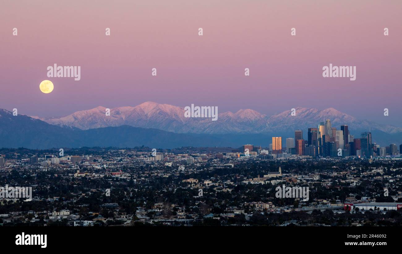 A scenic view of the full moon in the colorful sunset sky over Los ...