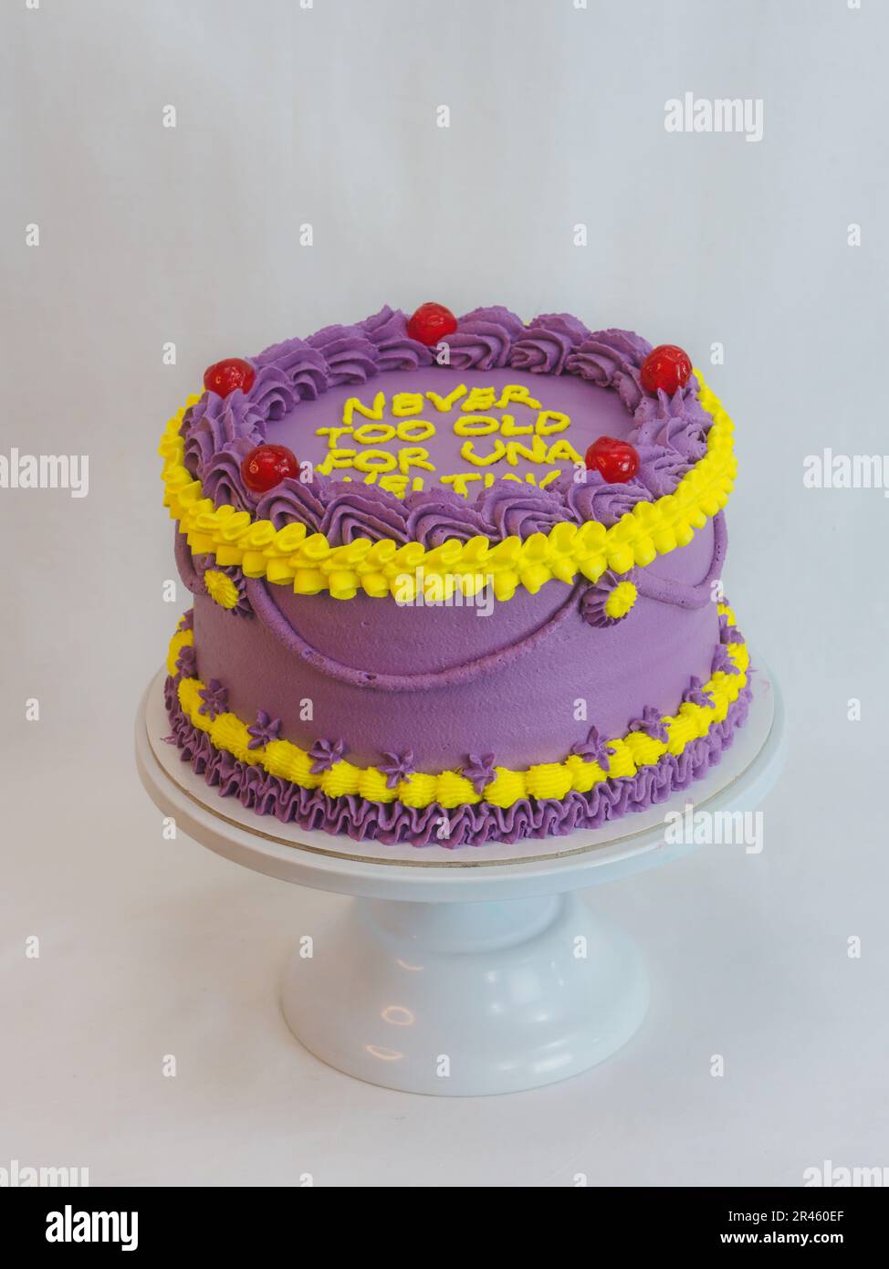 frosted icing violet yellow classic cilyndrical cake with text messagge ...