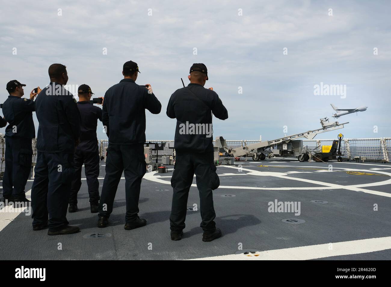 Crew from Brazil Navy ship Amazonas observe the launch of a ScanEagle ...