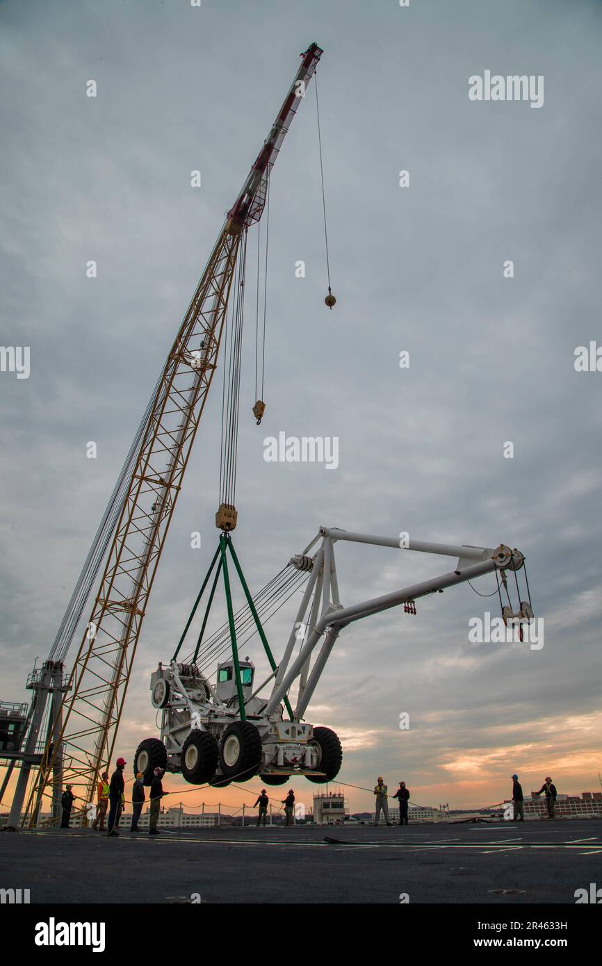 A crane prepares to lower the first-in-class aircraft carrier USS ...