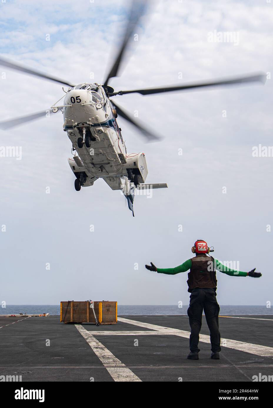 230406-N-MH015-1014 EAST CHINA SEA (April 6, 2023) A U.S. Navy Sailor directs a Super Puma (EC ...