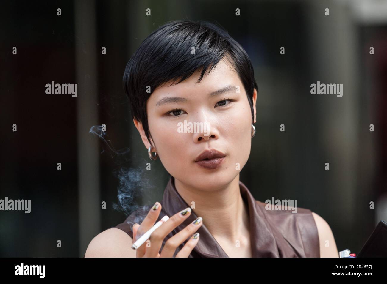 London, UK. 18th May, 2023. Model Kayako Higuchi smokes a cigarette as ...