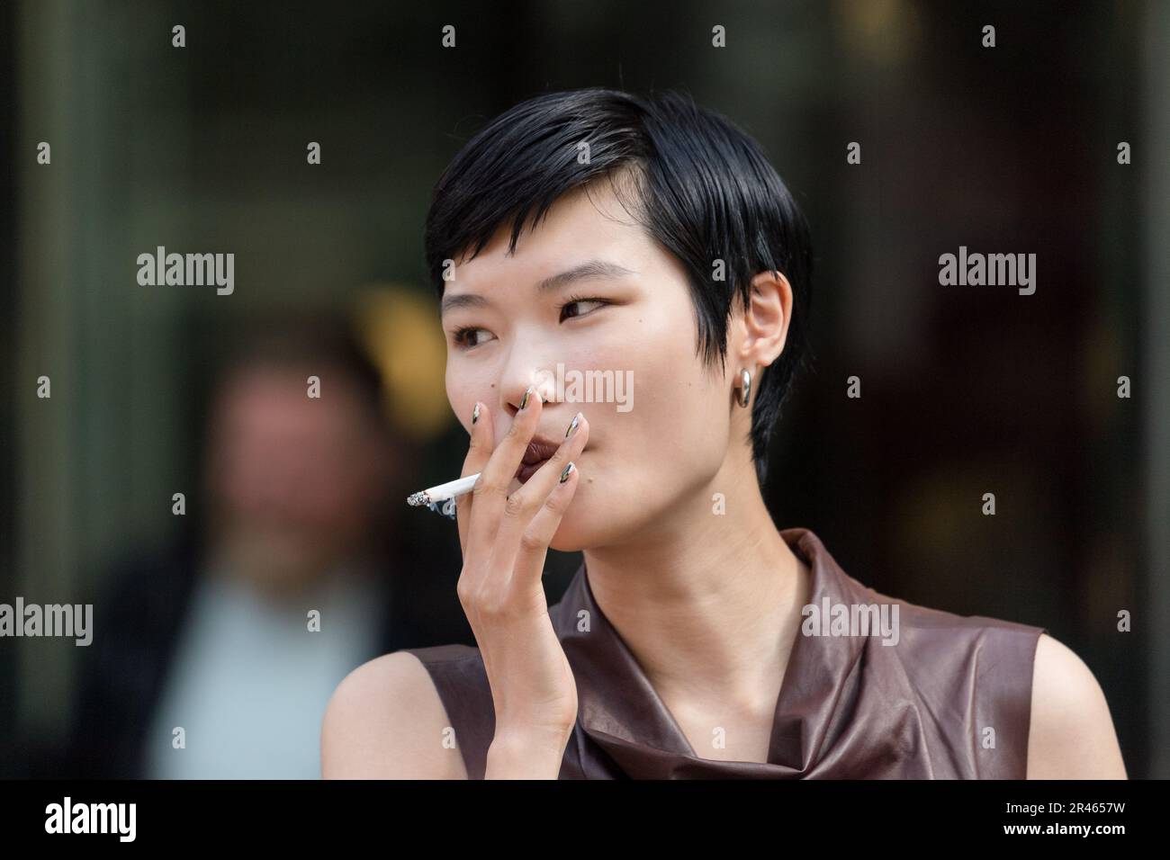 London, UK. 18th May, 2023. Model Kayako Higuchi smokes a cigarette as ...