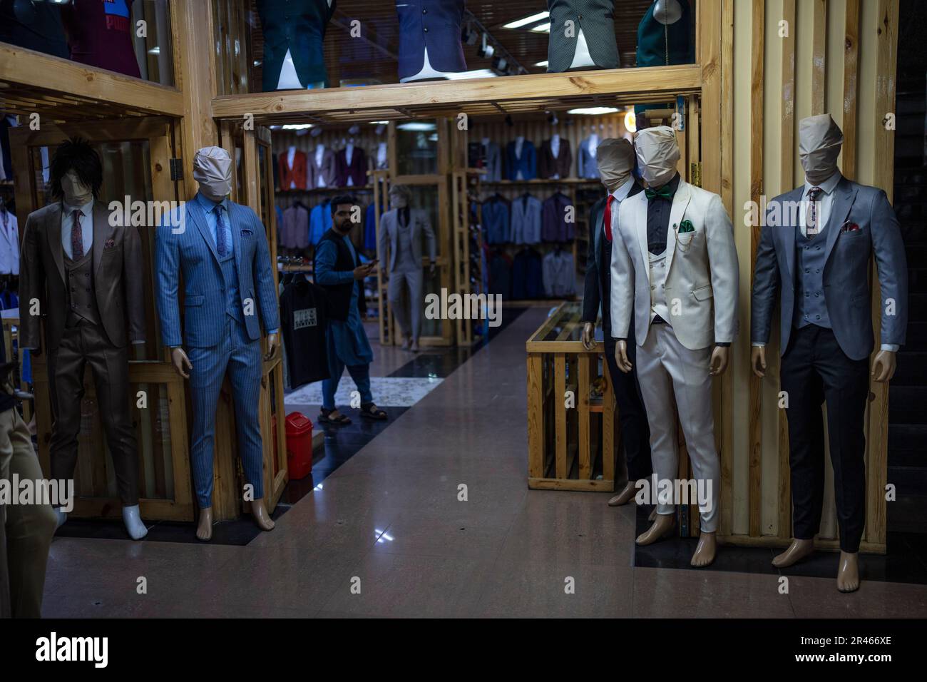 A vendor waits for customers in a clothing store downtown in Kabul ...
