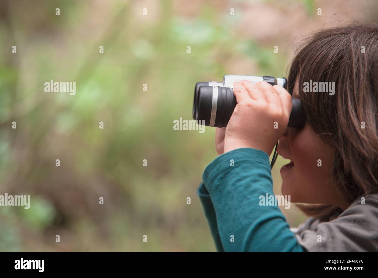 A close-up profile shot of a four-year-old child using binoculars to explore nature Stock Photo ...