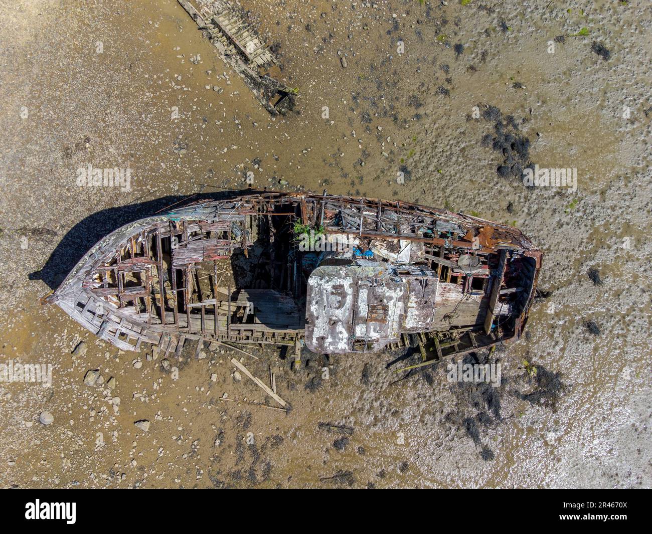 A desolate aerial view of a broken, abandoned boat, stranded in the ...