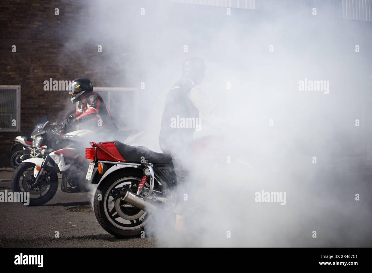 The motorcycles on the street raising a cloud of smoke Stock Photo - Alamy