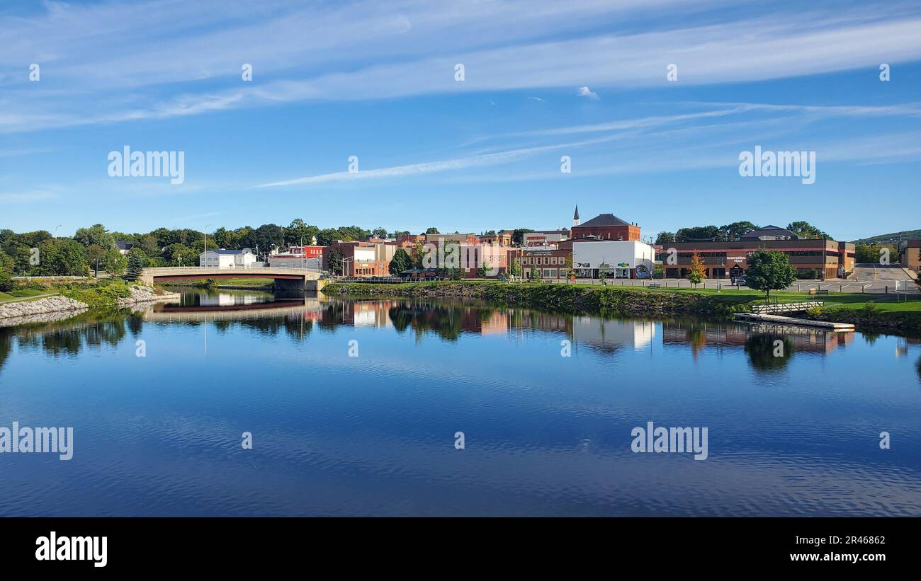 An idyllic scene of a small town in the countryside featuring a river ...