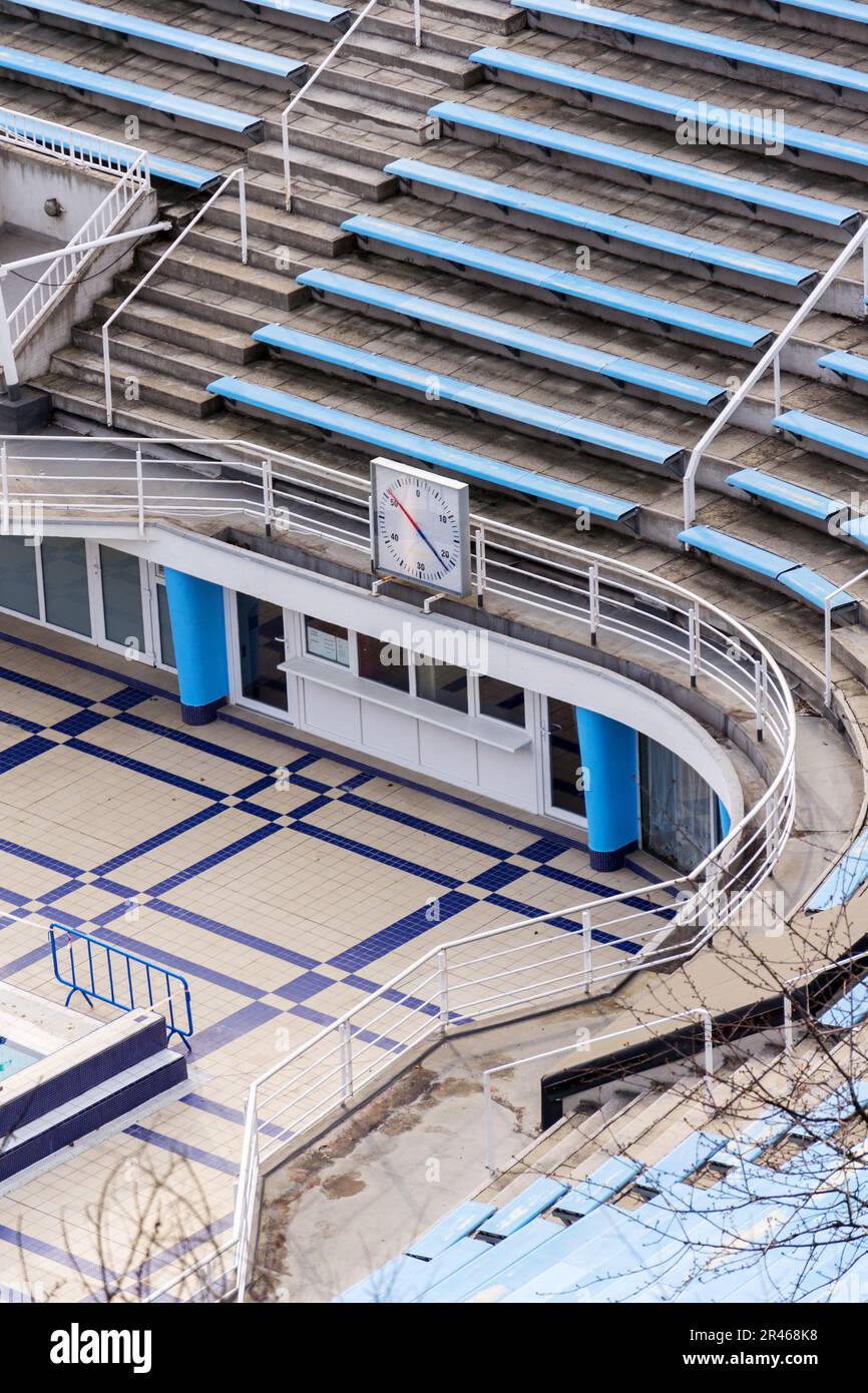 A stadium with rows of seating, staircases, and a swimming pool area ...