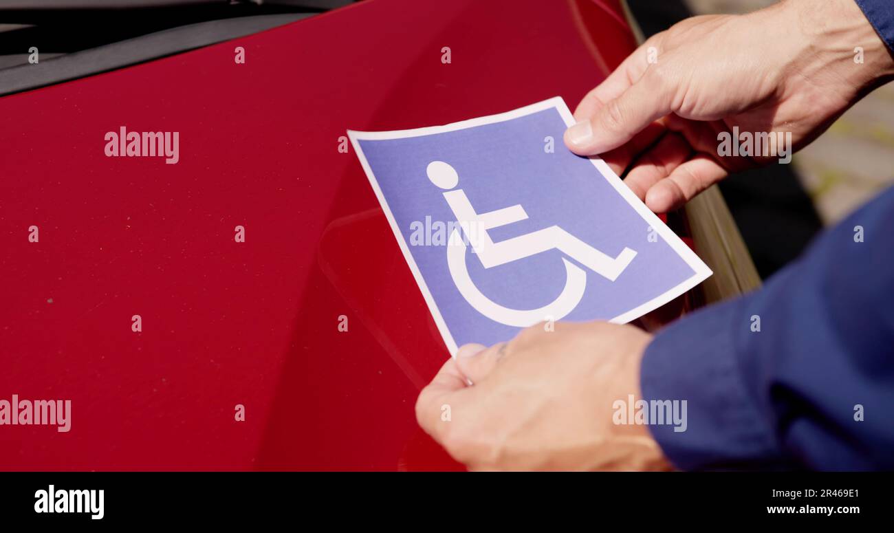 Driver Putting Wheelchair Sticker Sign On Car Vehicle Stock Photo - Alamy