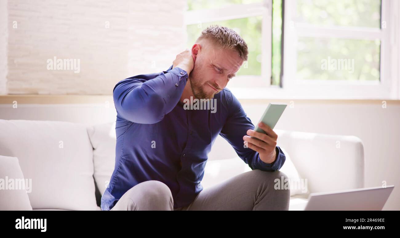 Man With Neck Pain Sitting Using Mobile Phone Stock Photo - Alamy