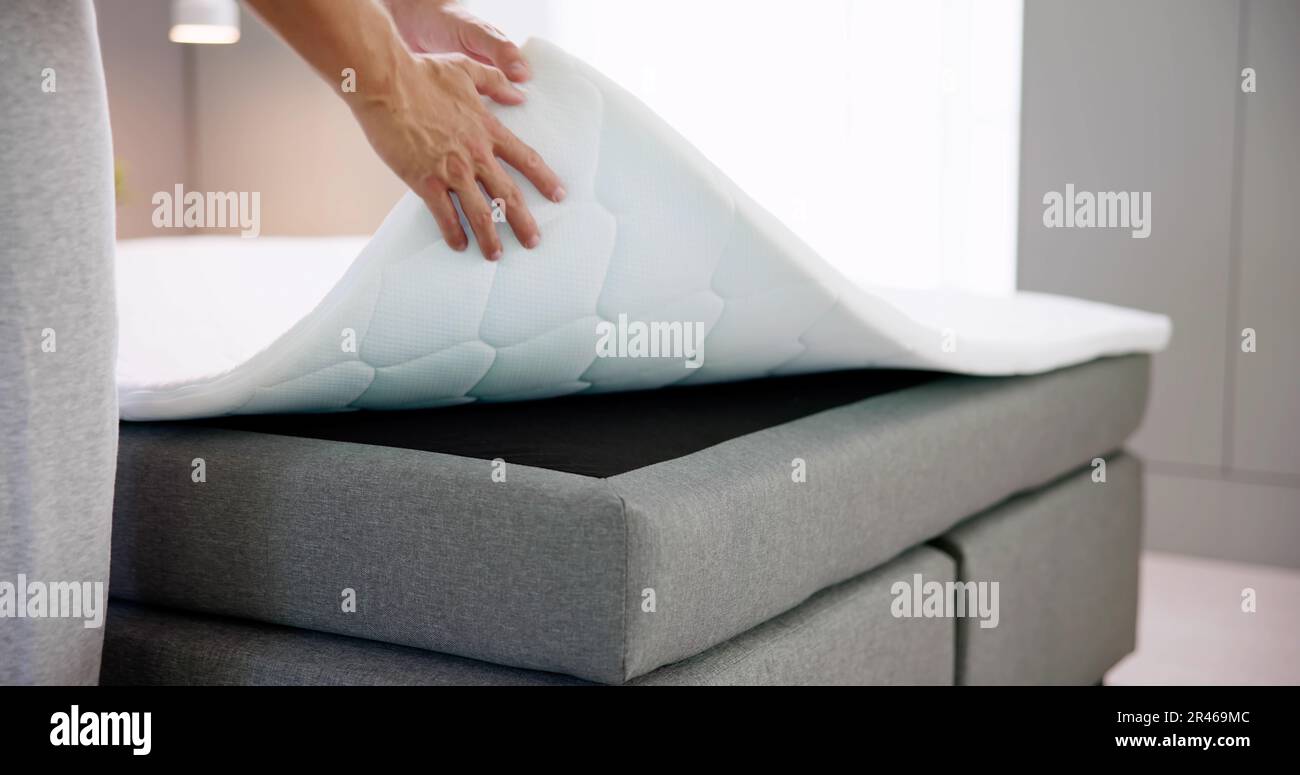 Mattress Topper Being Laid On Top Of The Bed Stock Photo - Alamy