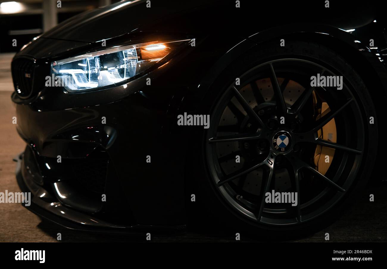 The wheel and lights of an exotic metallic black BMW M3 CS m power ...