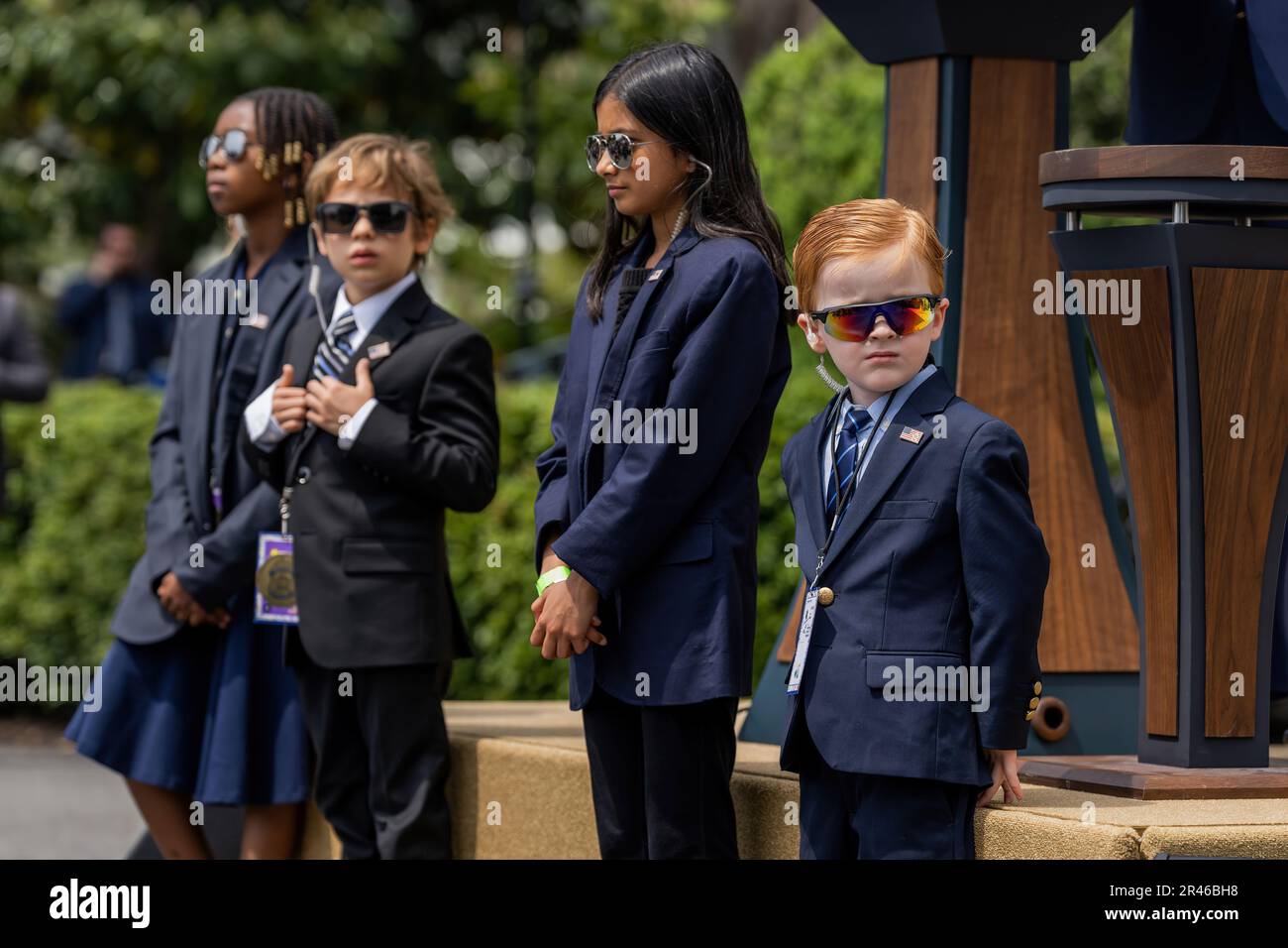Staff members’ children dressed as Secret Service agents stand by as ...