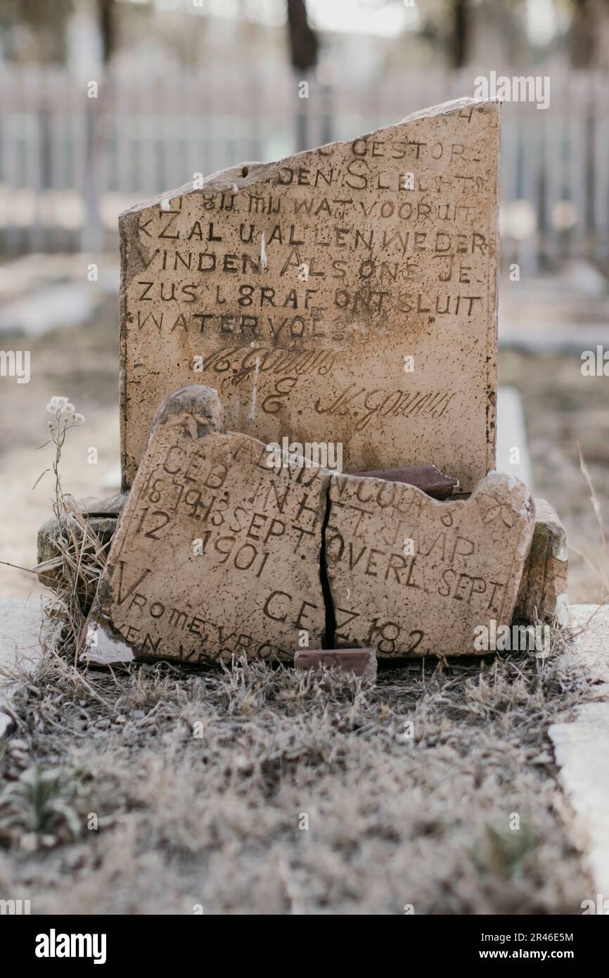 An old, broken cement gravestone with no visible markings, situated in ...