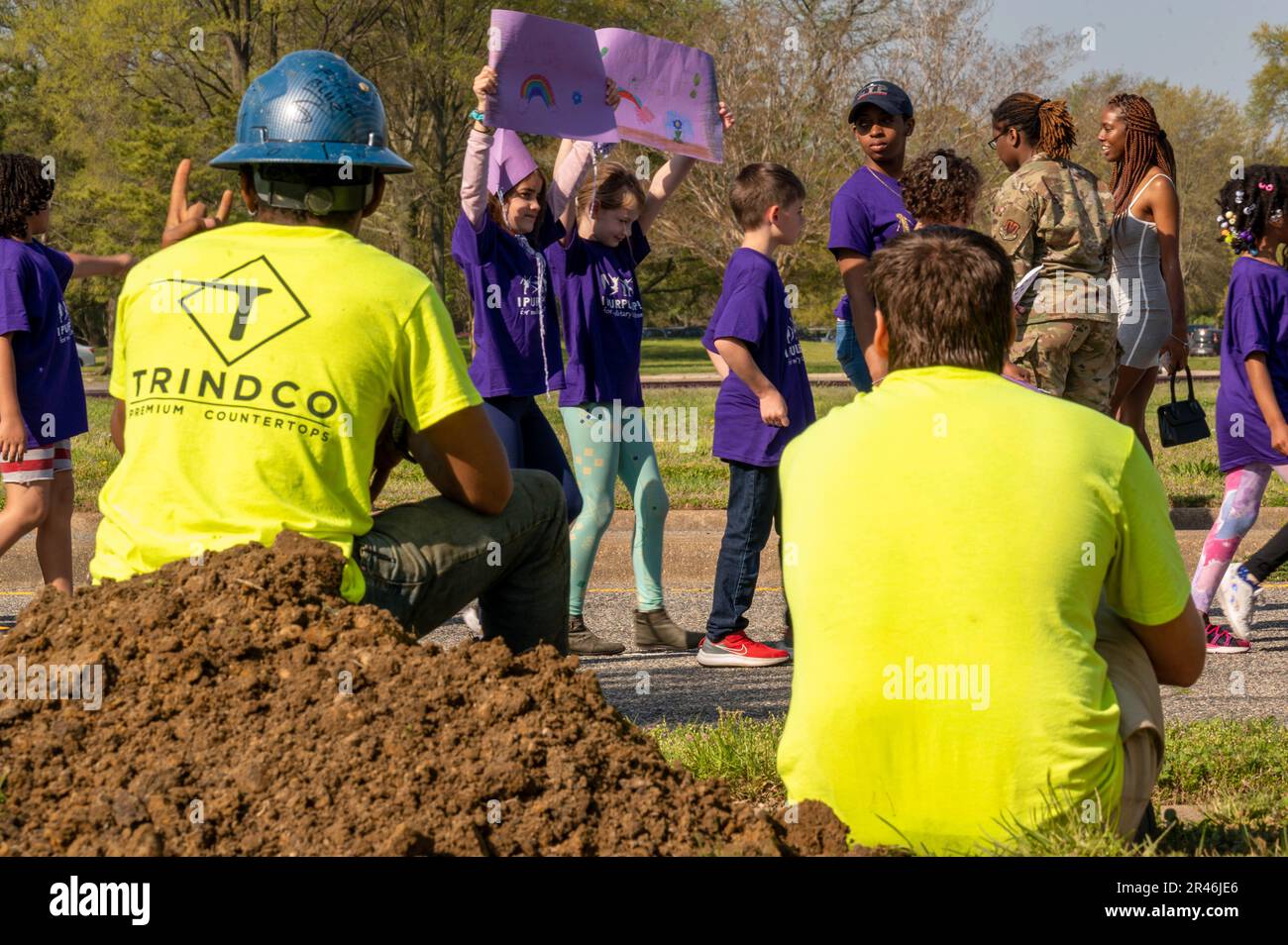 Construction workers watch as military children walk by their work site ...