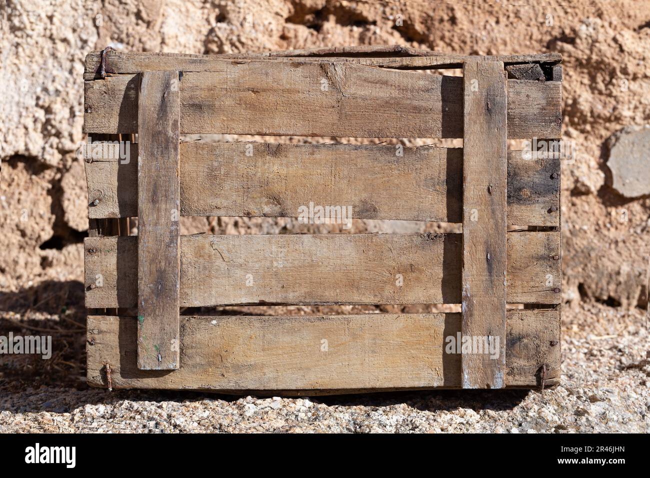 Front of old wooden box on rock. It has four horizontal slats and two ...