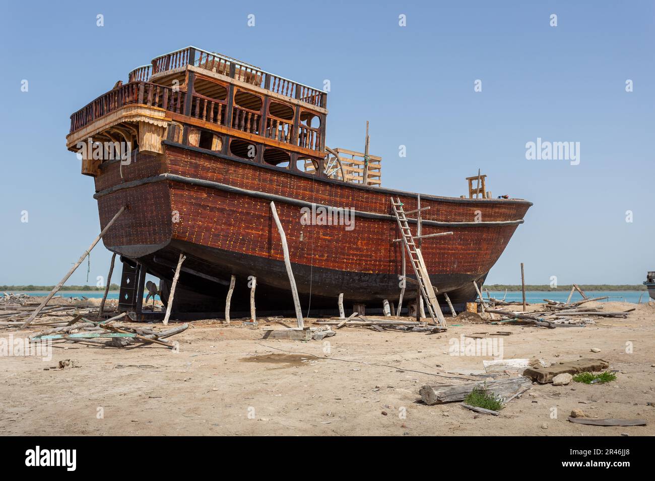 A vintage boat on the sandy shoreline with a rust-covered exterior in ...