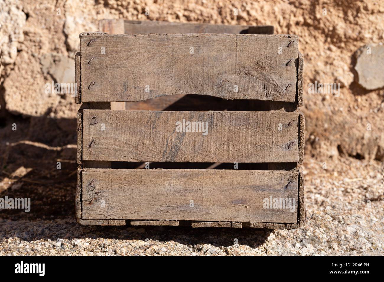 Side view of old wooden box on rock. It has three horizontal slats ...