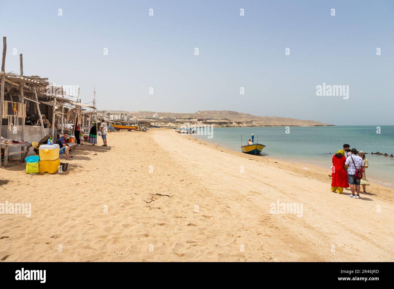 A family on the shoreline of a beach on Hengam Island, a destination ...