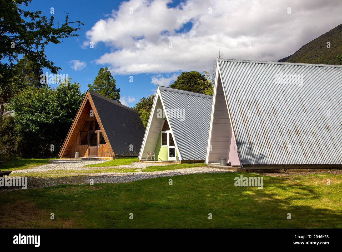 An idyllic scene of triangular-shaped homes in a lush park in Makarora ...