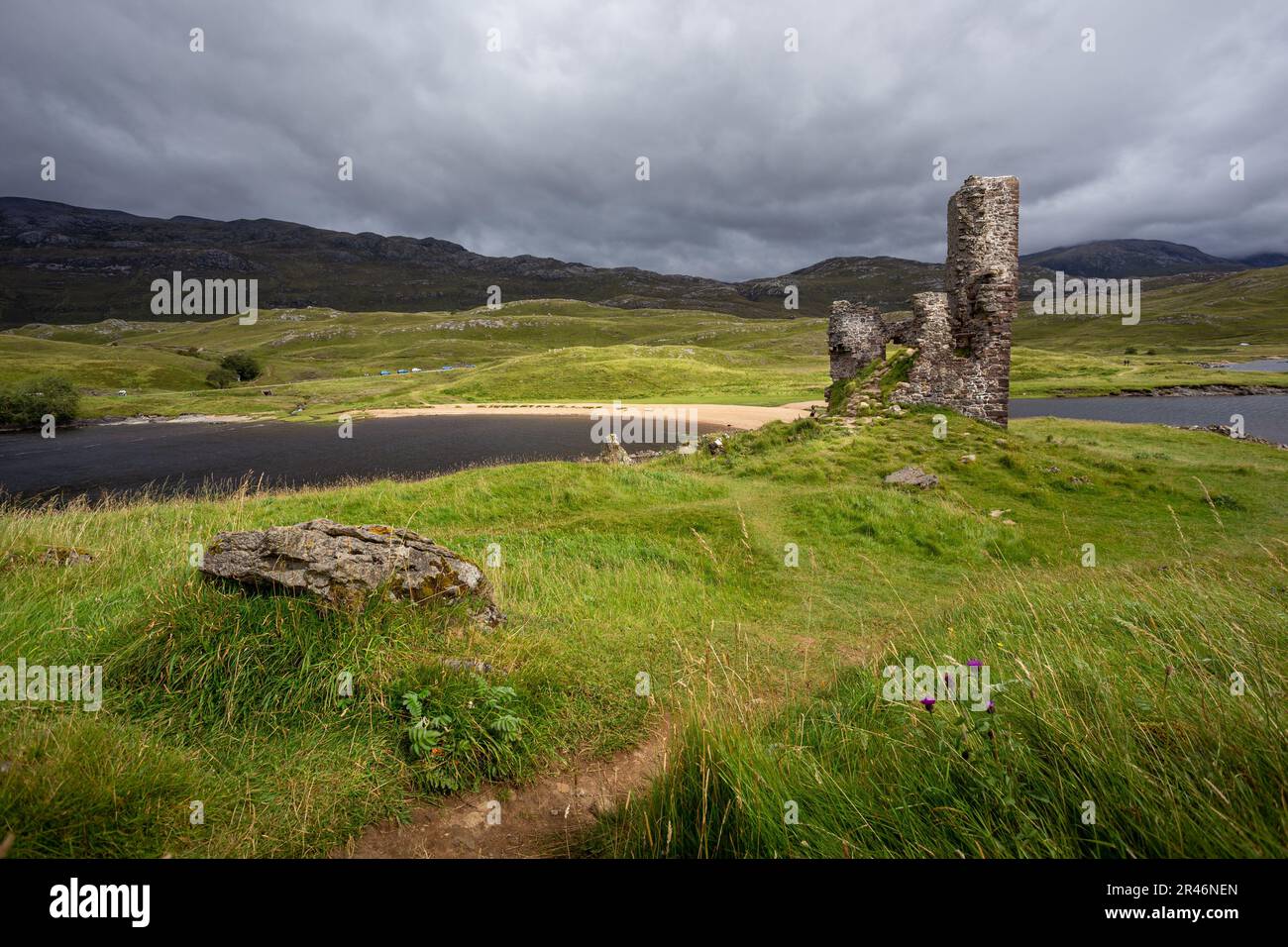 The ancient Ardvreck Castle ruin located on the edge of a tranquil lake ...