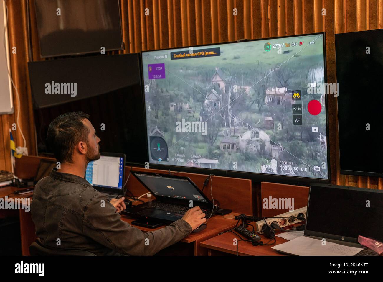 Member of Special Ukrainian army unit operating reconnaissance drones monitors on screen views ...