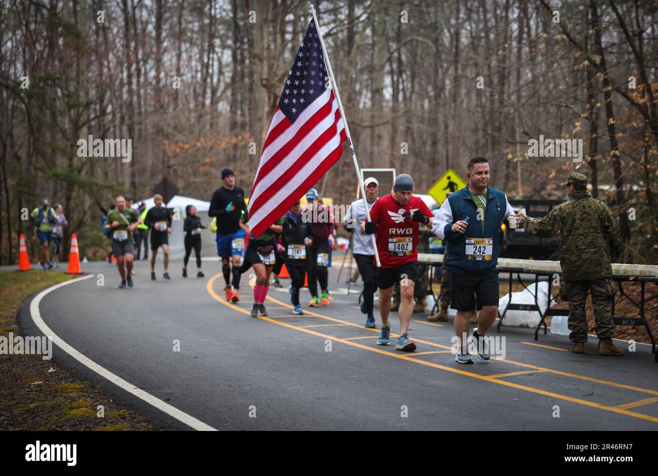 Scott Jenkins carries the United States flag while passing the first ...