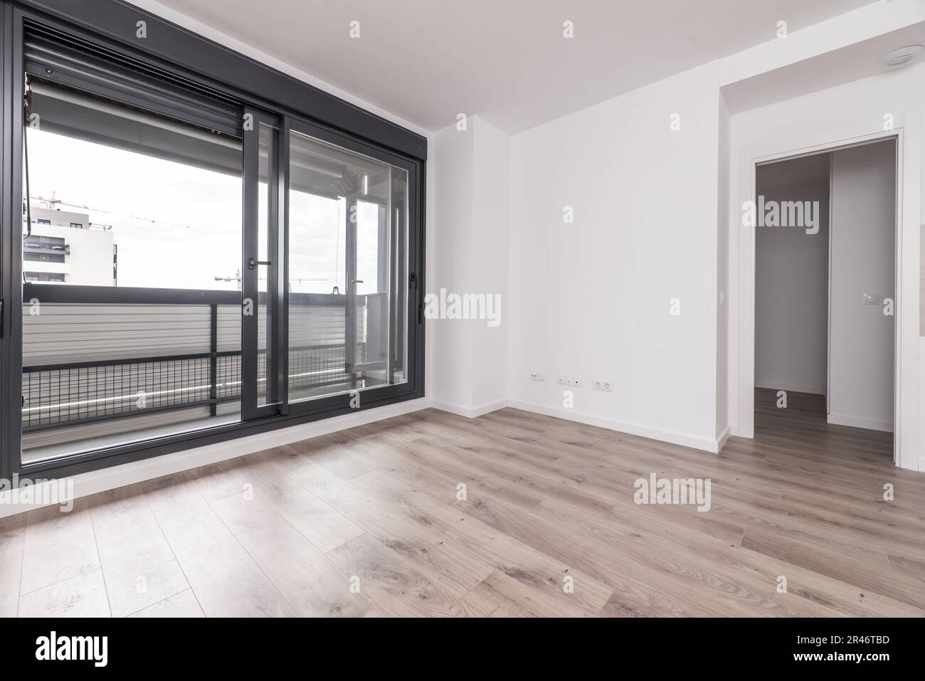 An empty living room of an apartment with wooden flooring with access ...