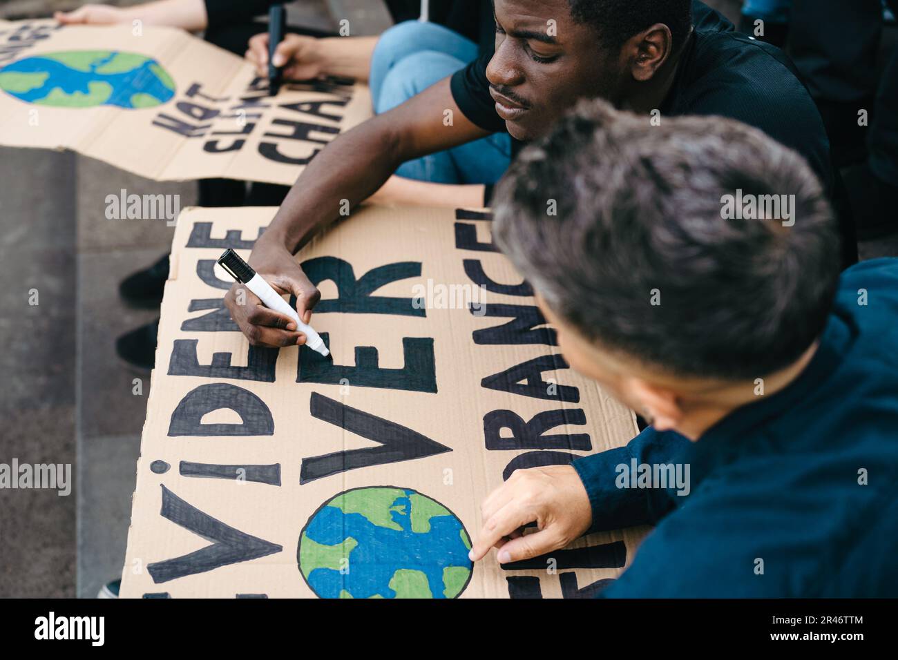 Multiracial activists preparing protest signs against climate change ...