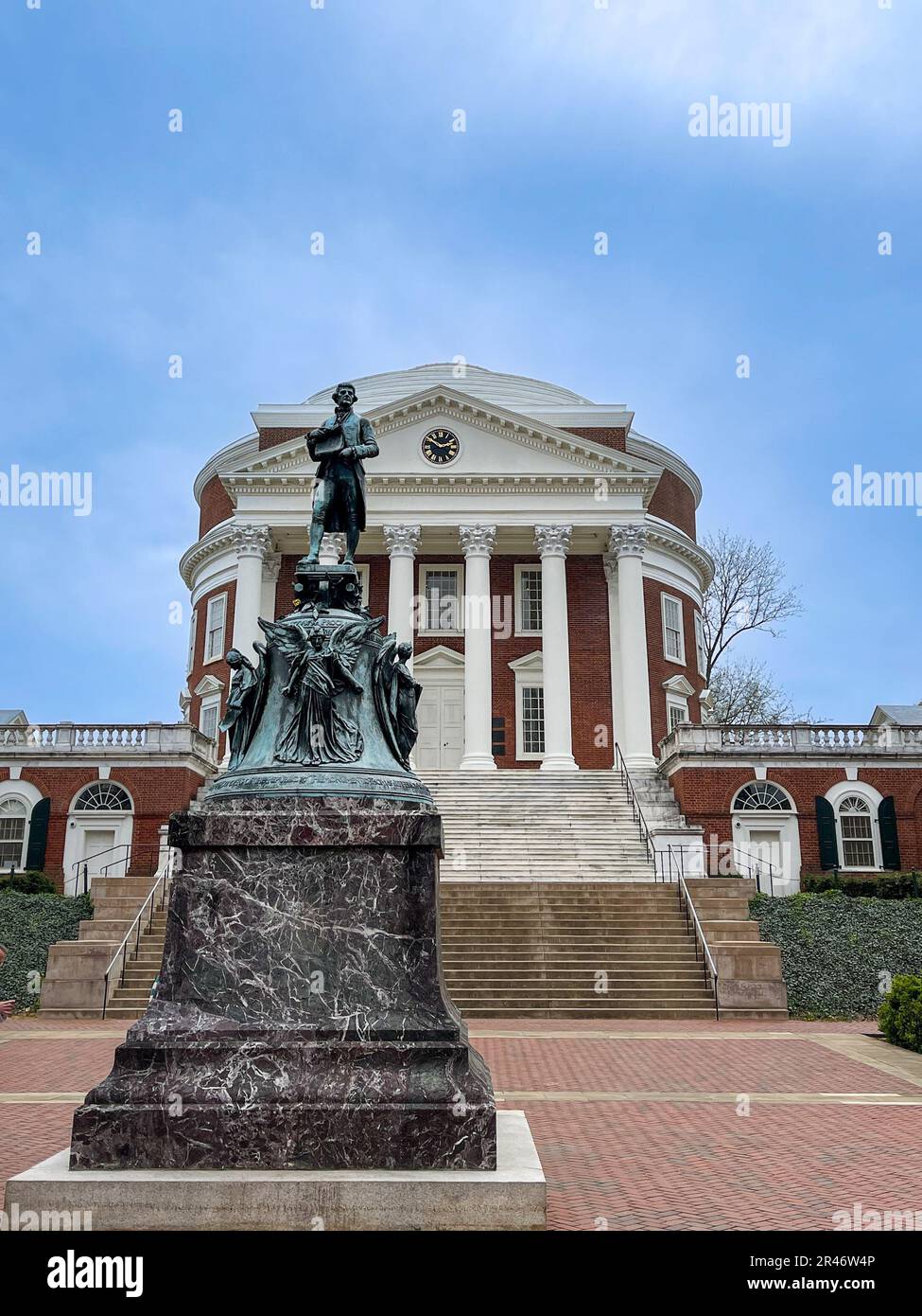 A large bronze statue stands atop a set of brick steps in a University ...