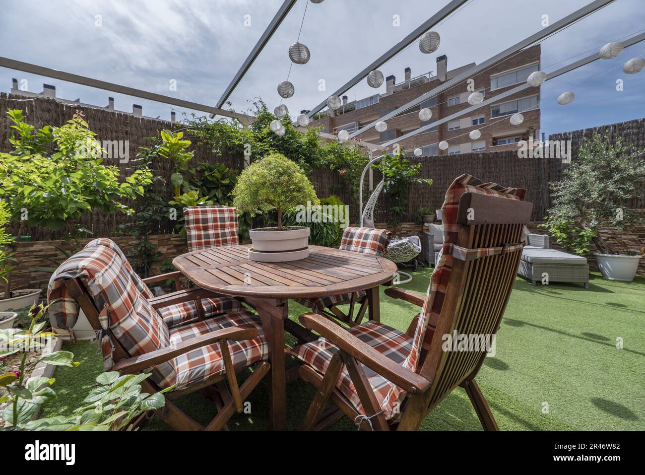 Terrace of a house with artificial grass floors with a teak wood dining ...