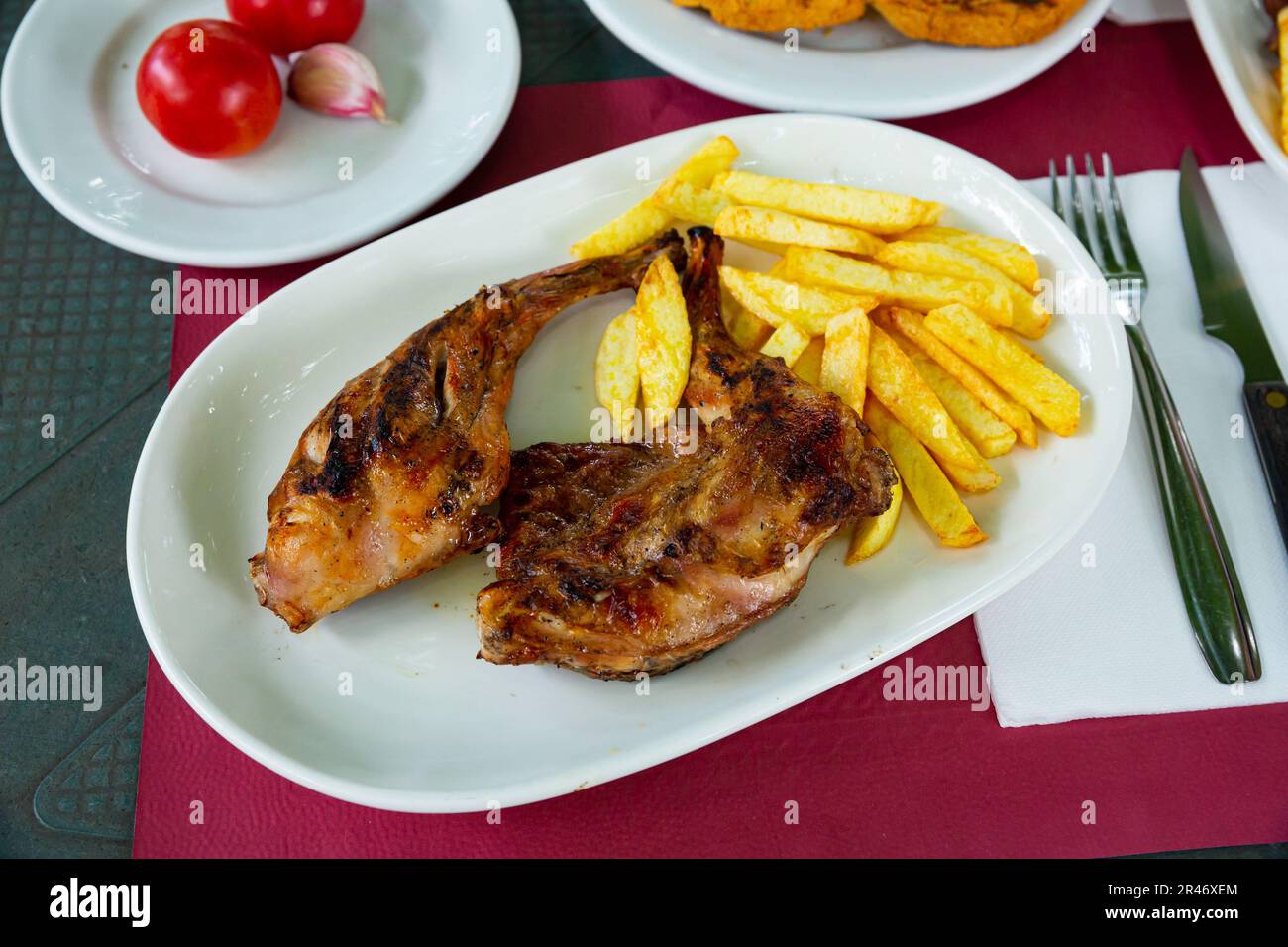 Dish of fried rabbit and French fries Stock Photo - Alamy