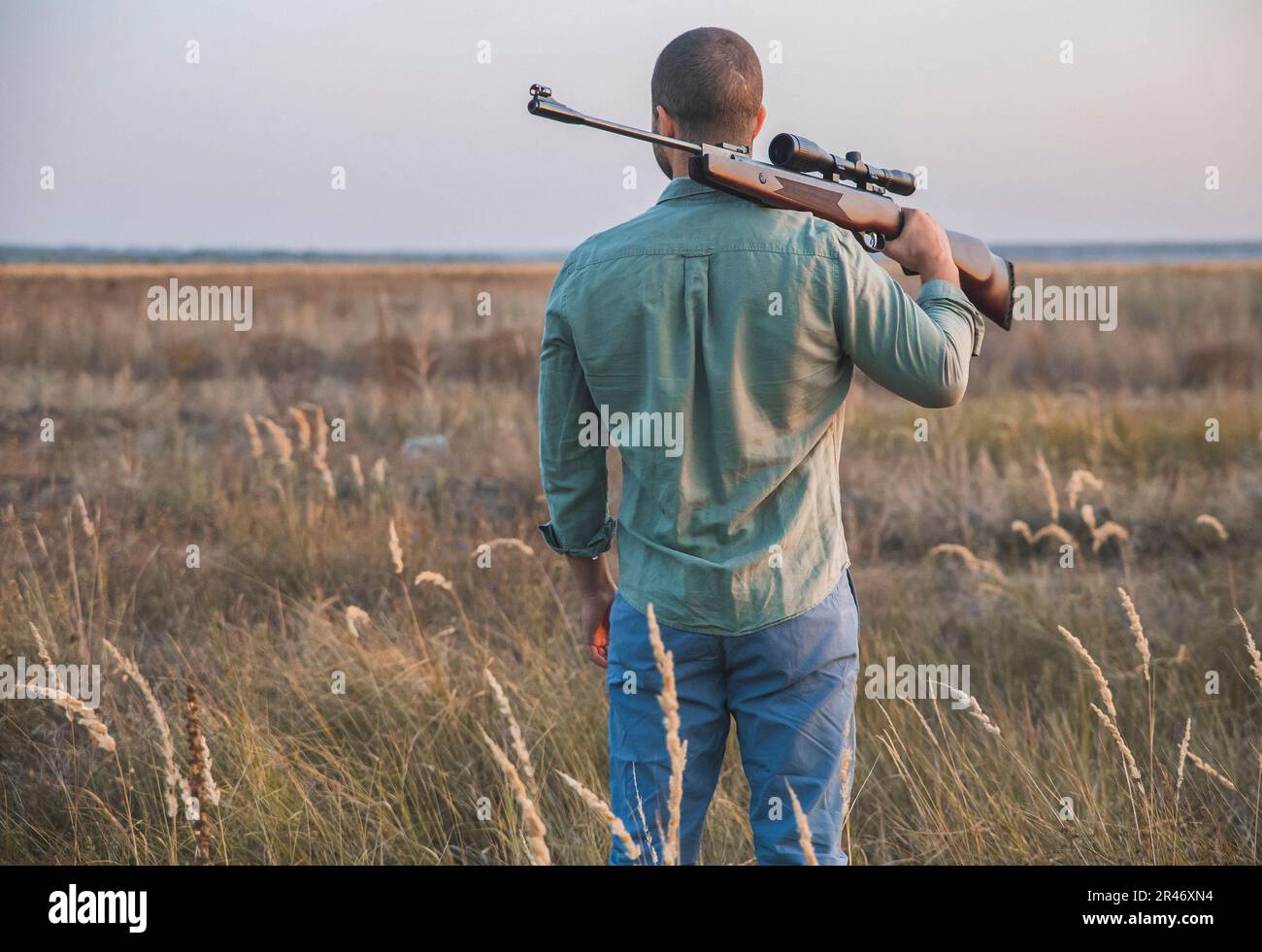 hunter in the field with his back putting the gun on his shoulder Stock ...