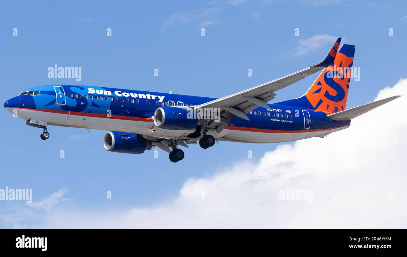 A Sun Country Airlines aircraft soaring against a blue sky backdrop ...