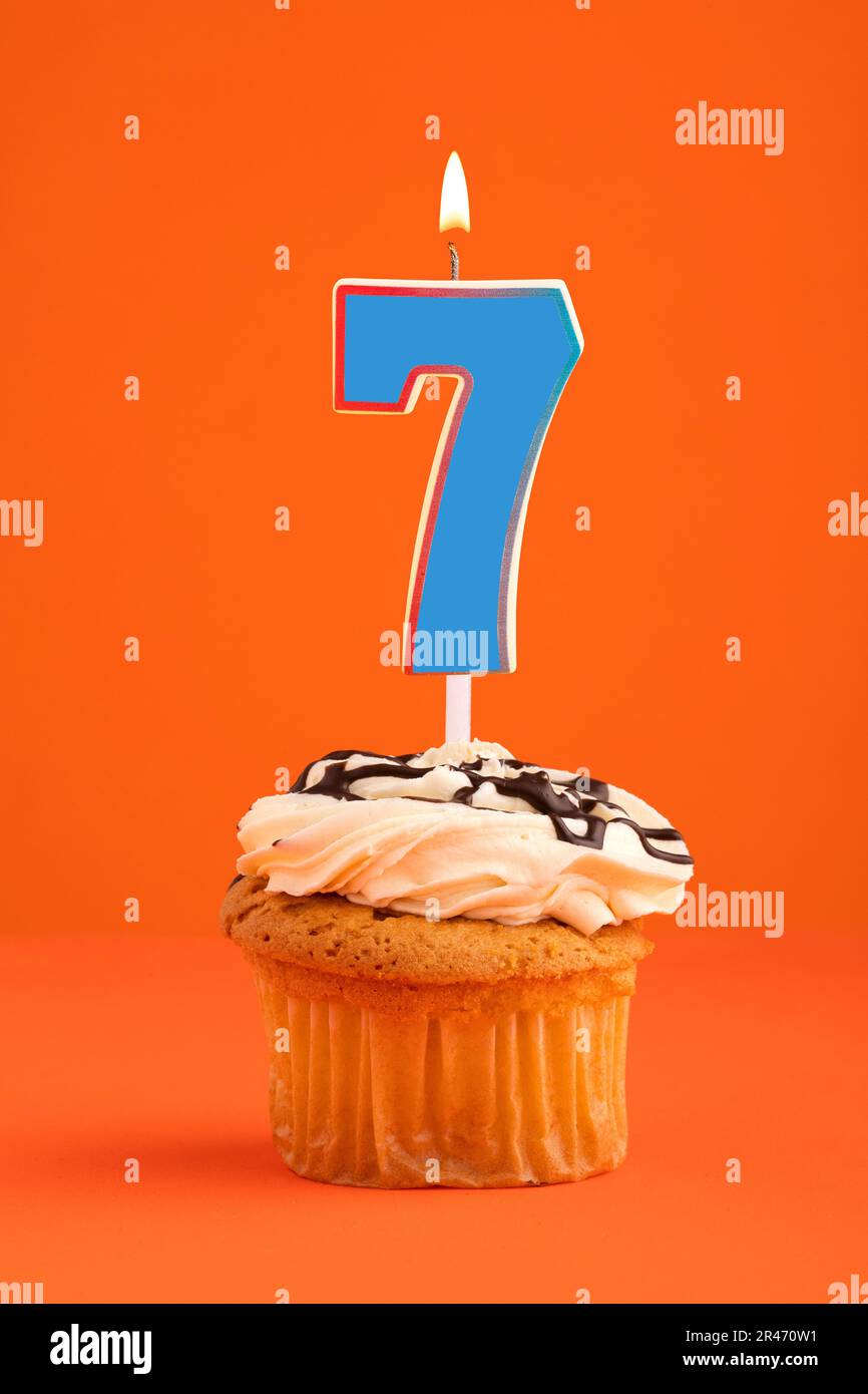 Blue number 7 candle - Birthday cake on orange background Stock Photo ...