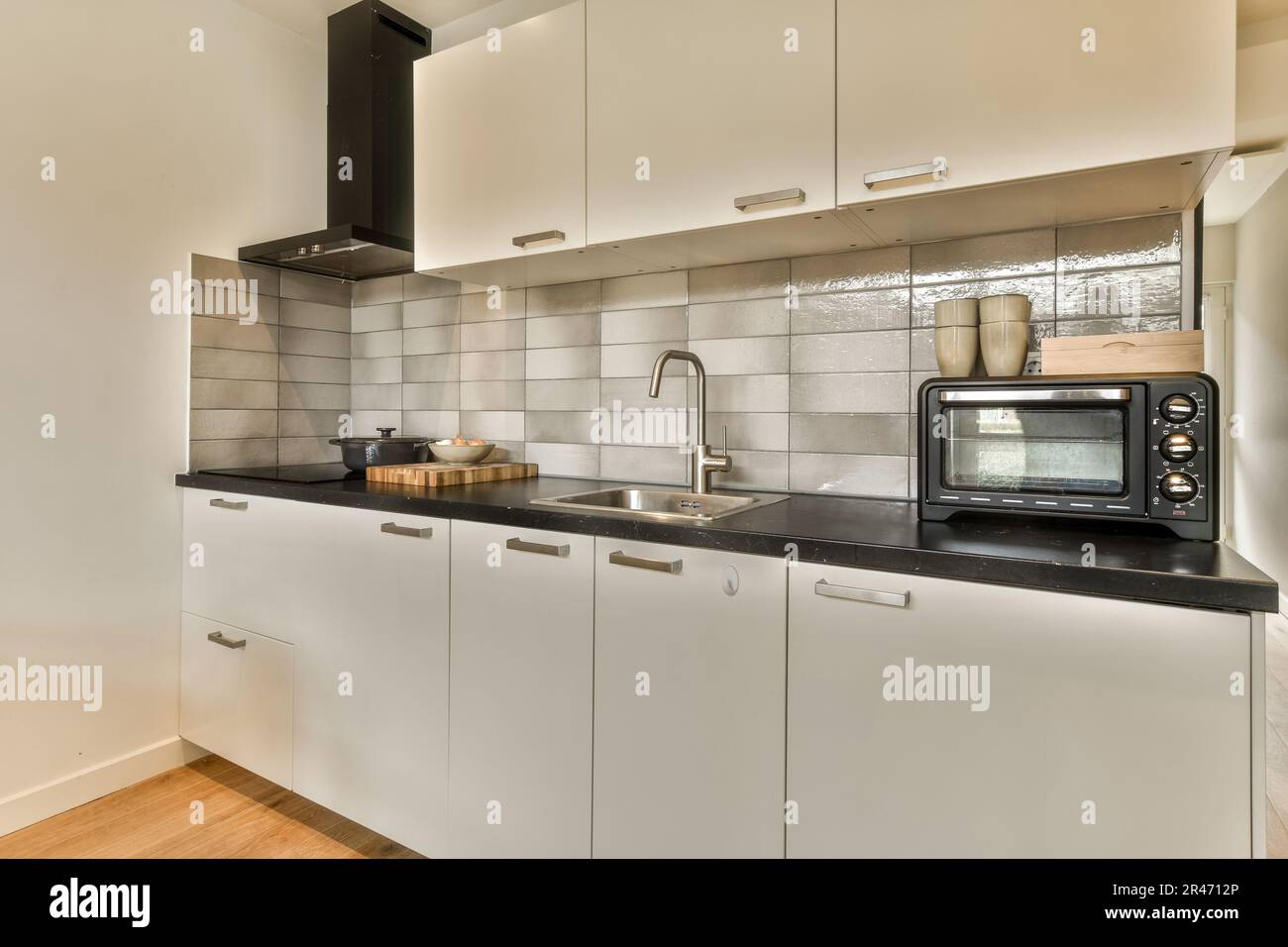 a kitchen with white cupboards and black counter tops on the counters ...