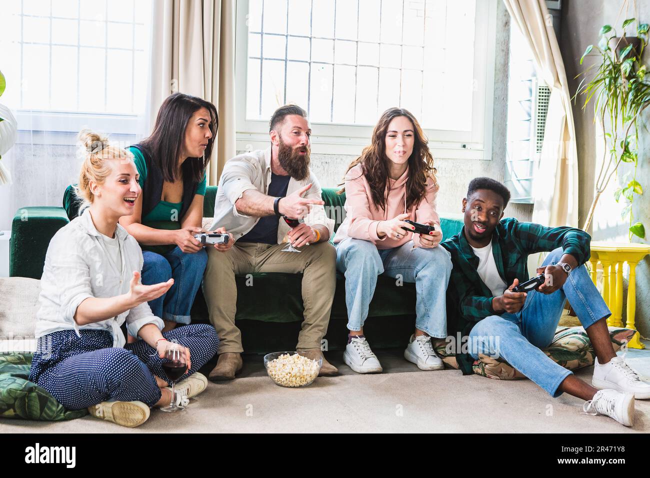 Multiethnic mixed group of friends having fun playing video games ...