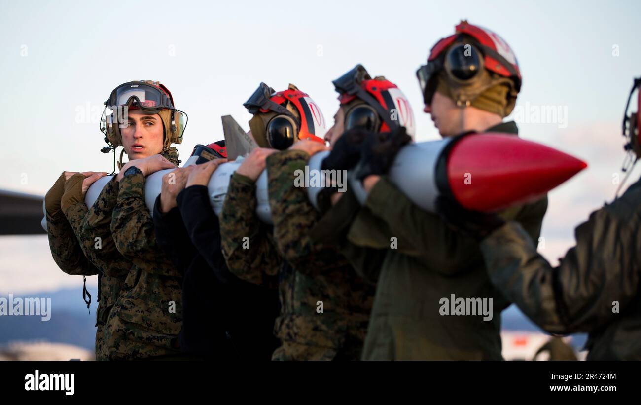U.S. Marines with Marine Fighter Attack Squadron 242 prepare to mount an AIM-120 Advanced Medium ...