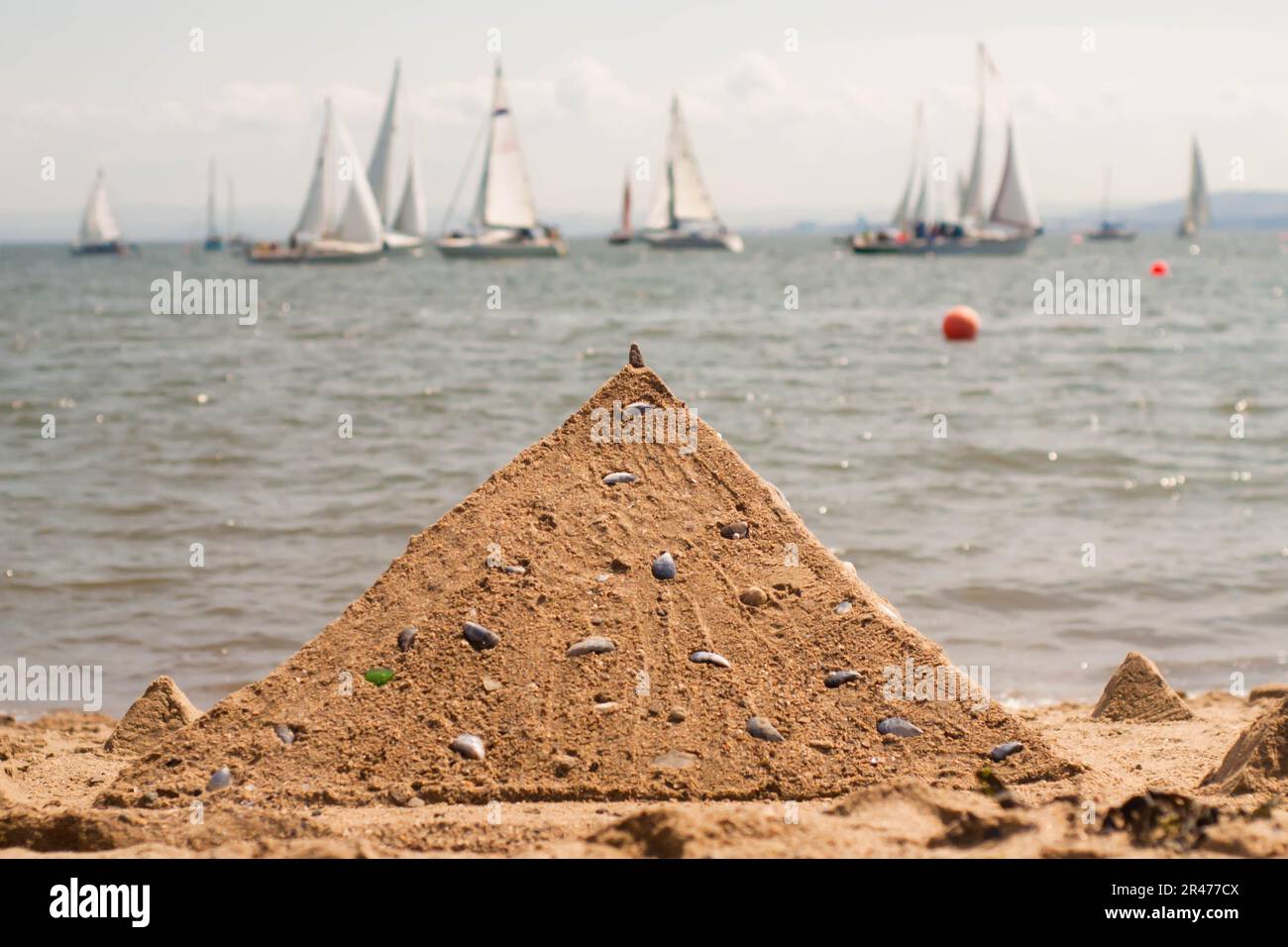 A deserted sand tower wind sand and pebbles by the shoreline with a ...