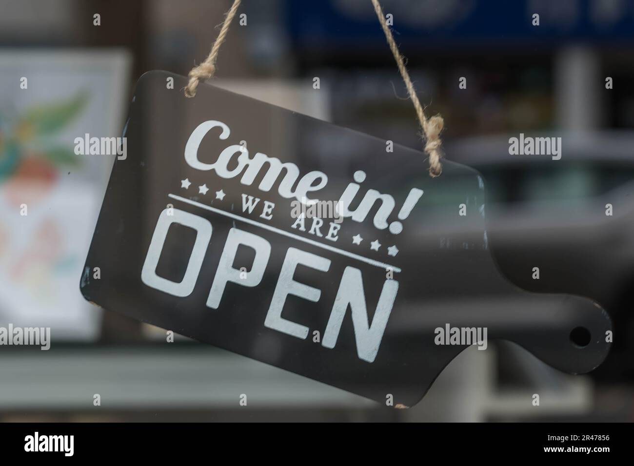 An advertising sign "Come in, we are open" - shop sign on a shop window ...