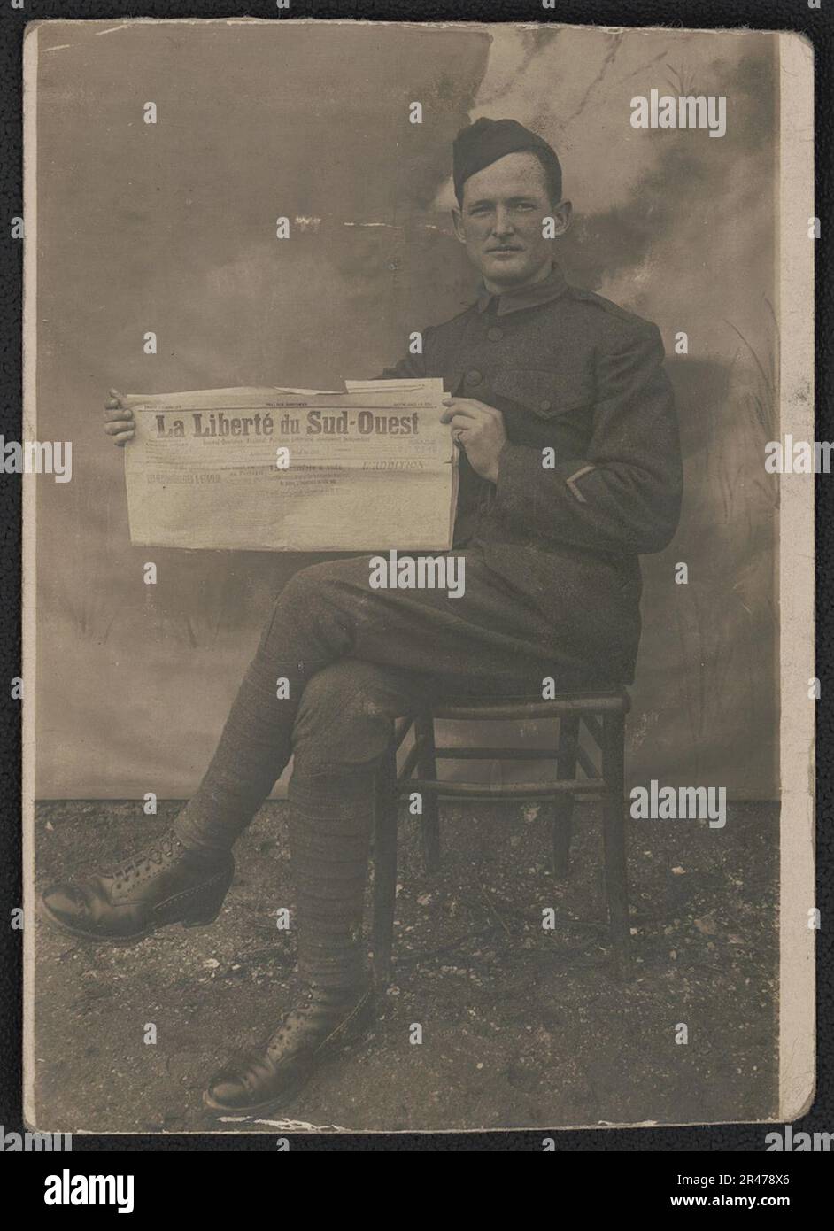 Unidentified soldier in uniform holding French newspaper, La Liberté du ...