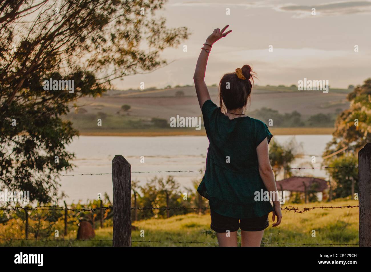 young woman from back making peace sign Stock Photo - Alamy